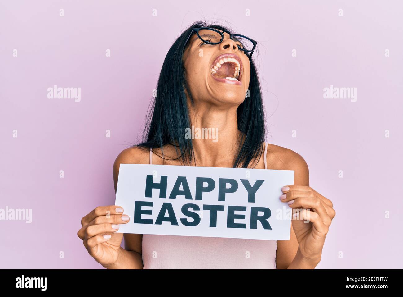 Young african american woman holding happy easter message paper angry ...