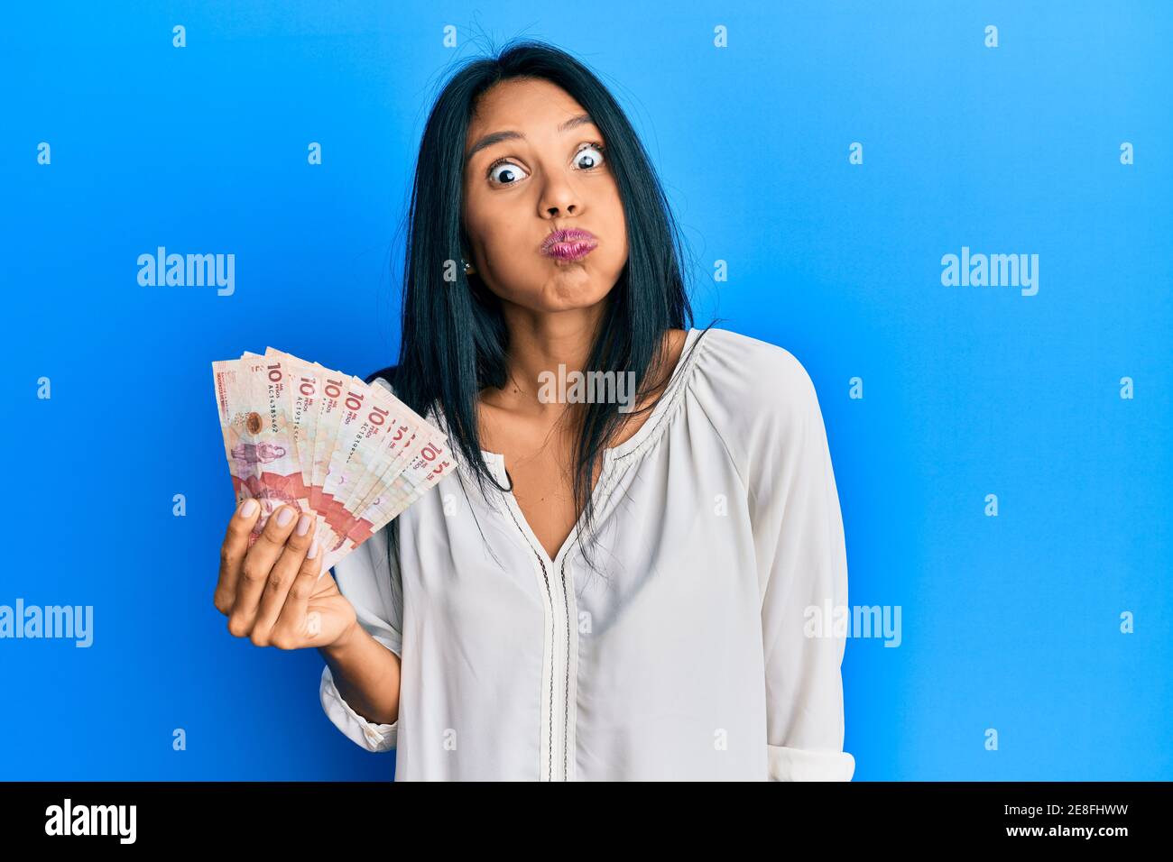 Young african american woman holding 10 colombian pesos banknotes ...