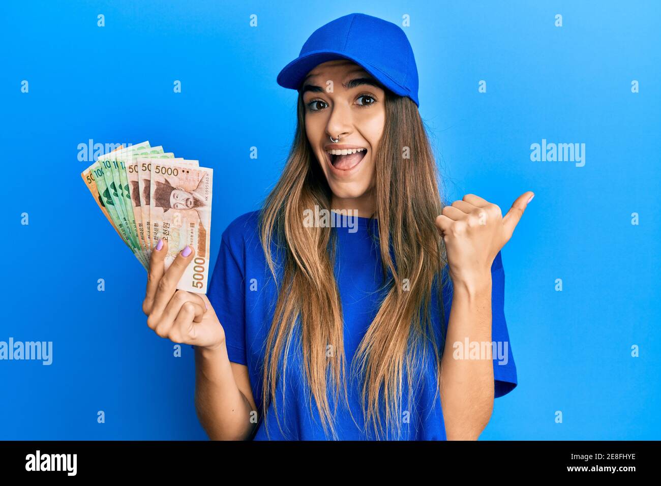 Young hispanic woman wearing delivery uniform and cap holding south ...