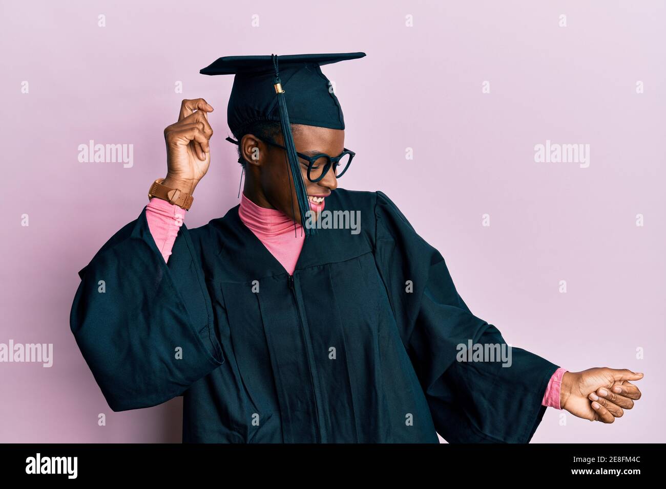 Young african american girl wearing graduation cap and ceremony robe ...