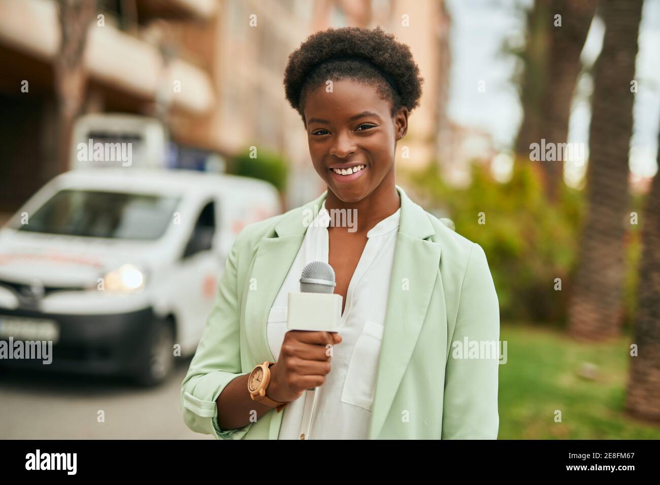 Young african american reporter woman using microphone at the city Stock Photo - Alamy