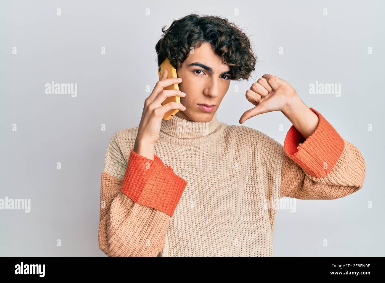 Hispanic young man having conversation talking on the smartphone with ...