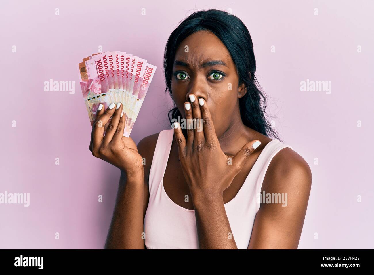 Young African American Woman Holding Indonesian Rupiah Banknotes