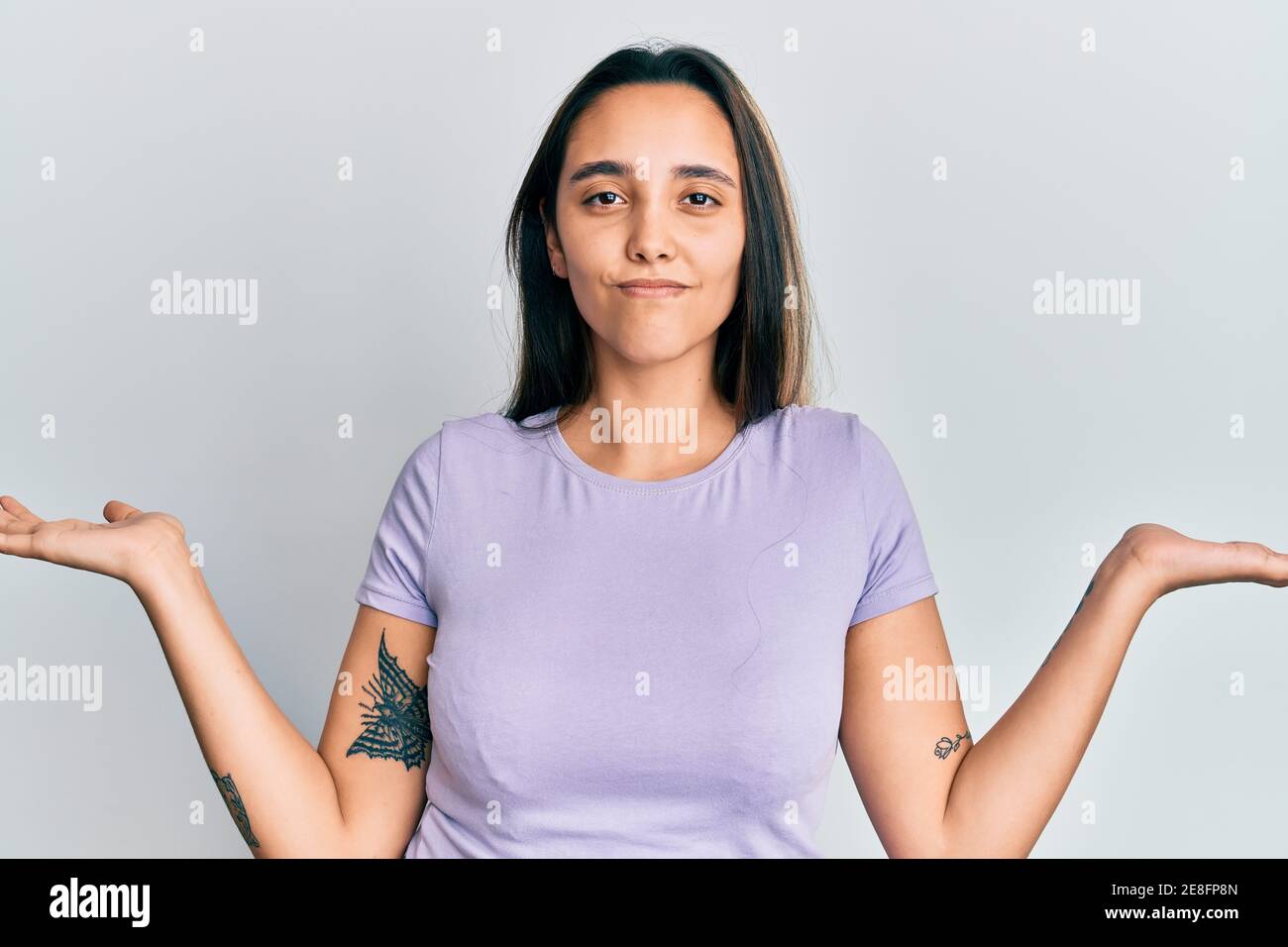 Young hispanic woman wearing casual clothes clueless and confused with ...