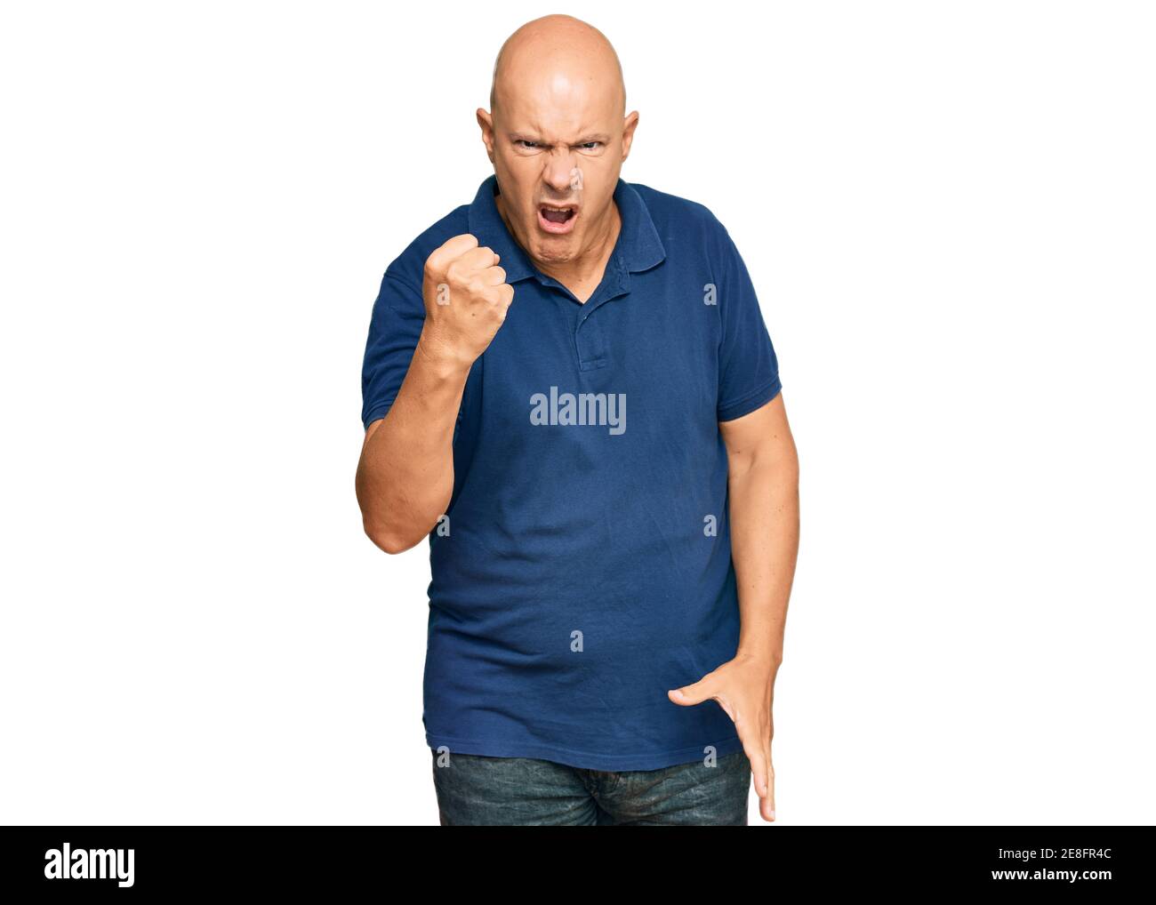 Middle age bald man wearing casual clothes angry and mad raising fist ...