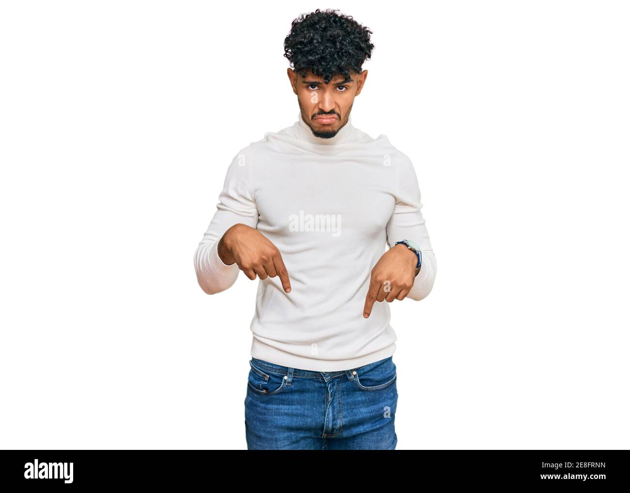 Young arab man wearing casual winter sweater pointing down looking sad ...