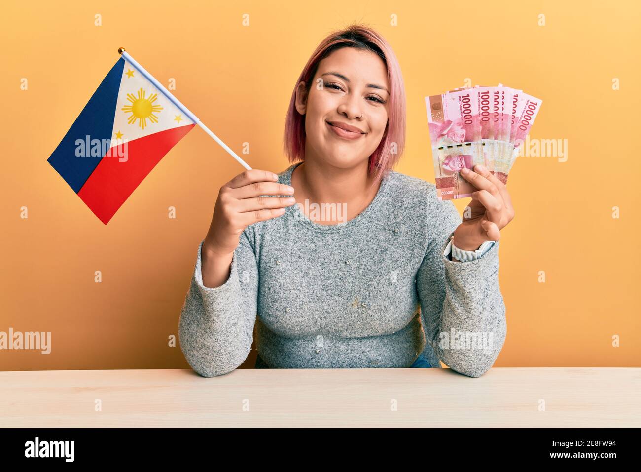 Hispanic woman with pink hair holding philippine flag and philippines ...