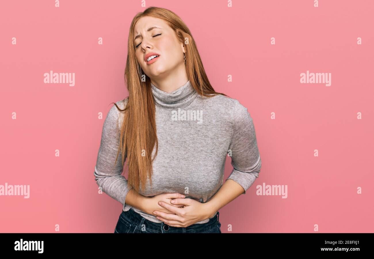 Young irish woman wearing casual clothes with hand on stomach because ...
