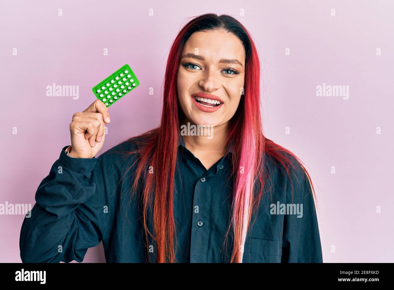 Young caucasian woman holding birth control pills looking positive and ...