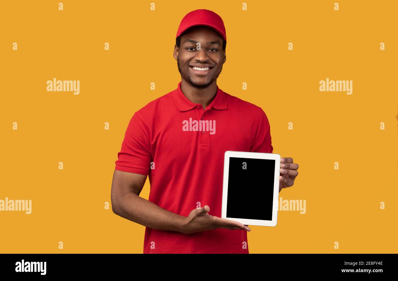 Black delivery man holding tablet with blank screen for mockup Stock ...
