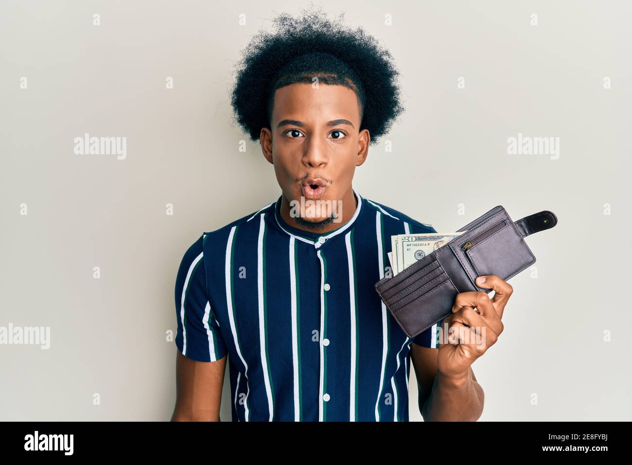 African american man with afro hair holding wallet and dollars ...