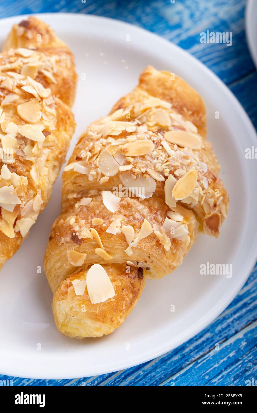Morning breakfast. Fresh French croissant in a plate on a blue wood ...