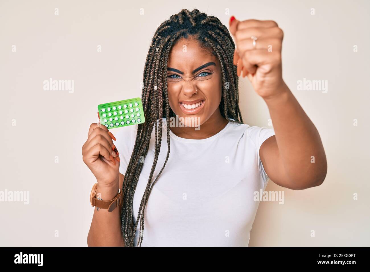 Young african american woman with braids holding birth control pills ...