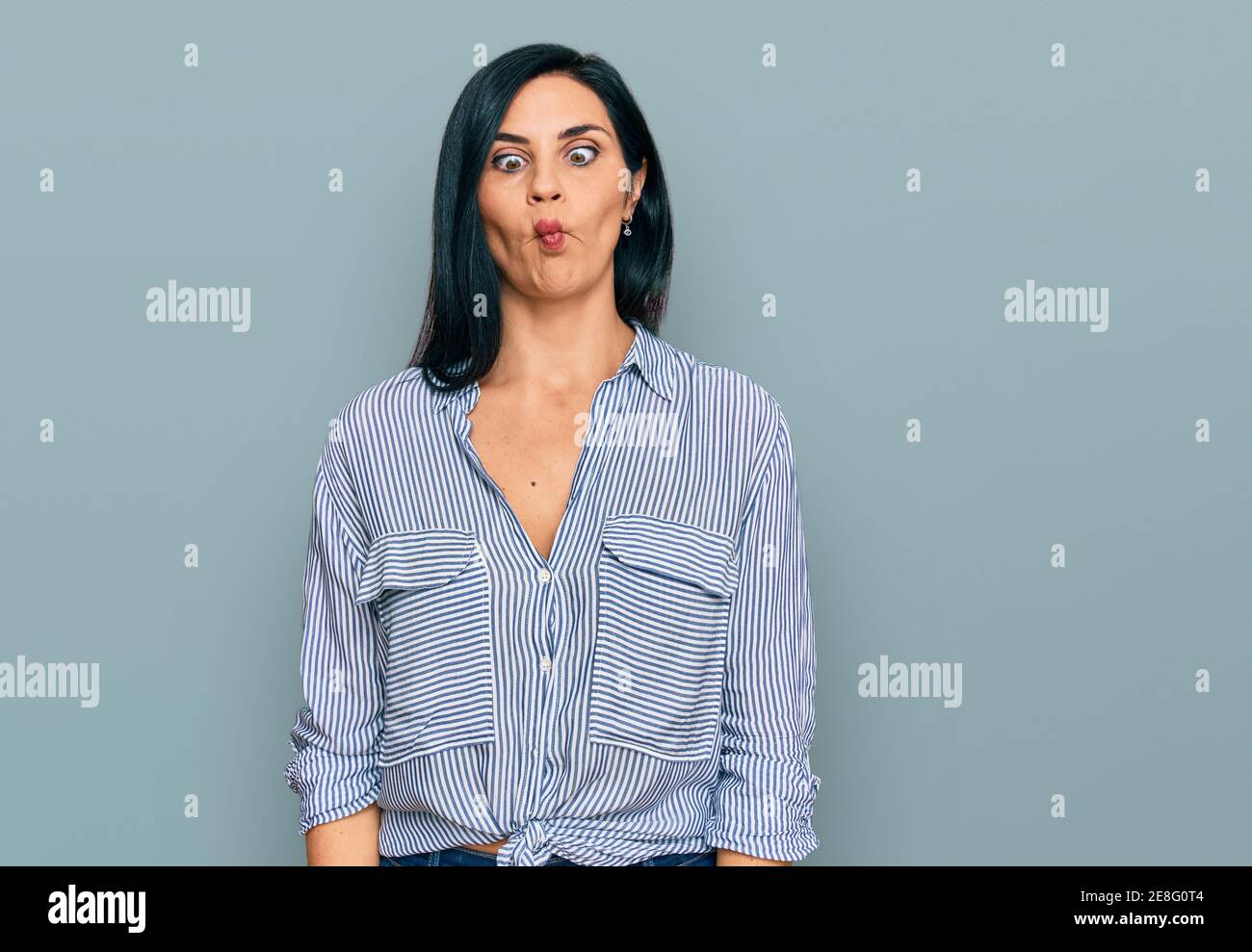 Young caucasian woman wearing casual clothes making fish face with lips ...