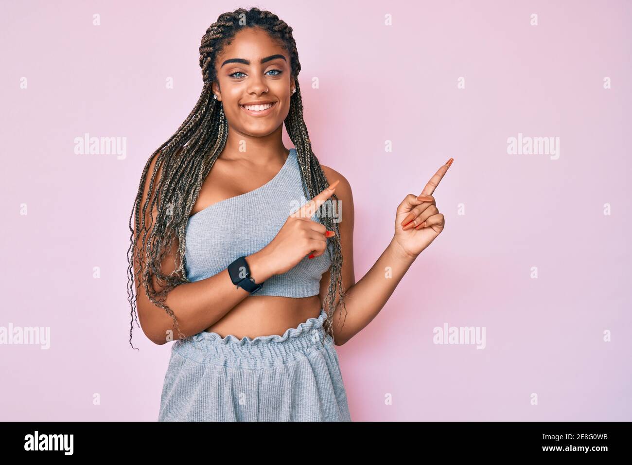 Young african american woman with braids wearing sports clothes smiling ...