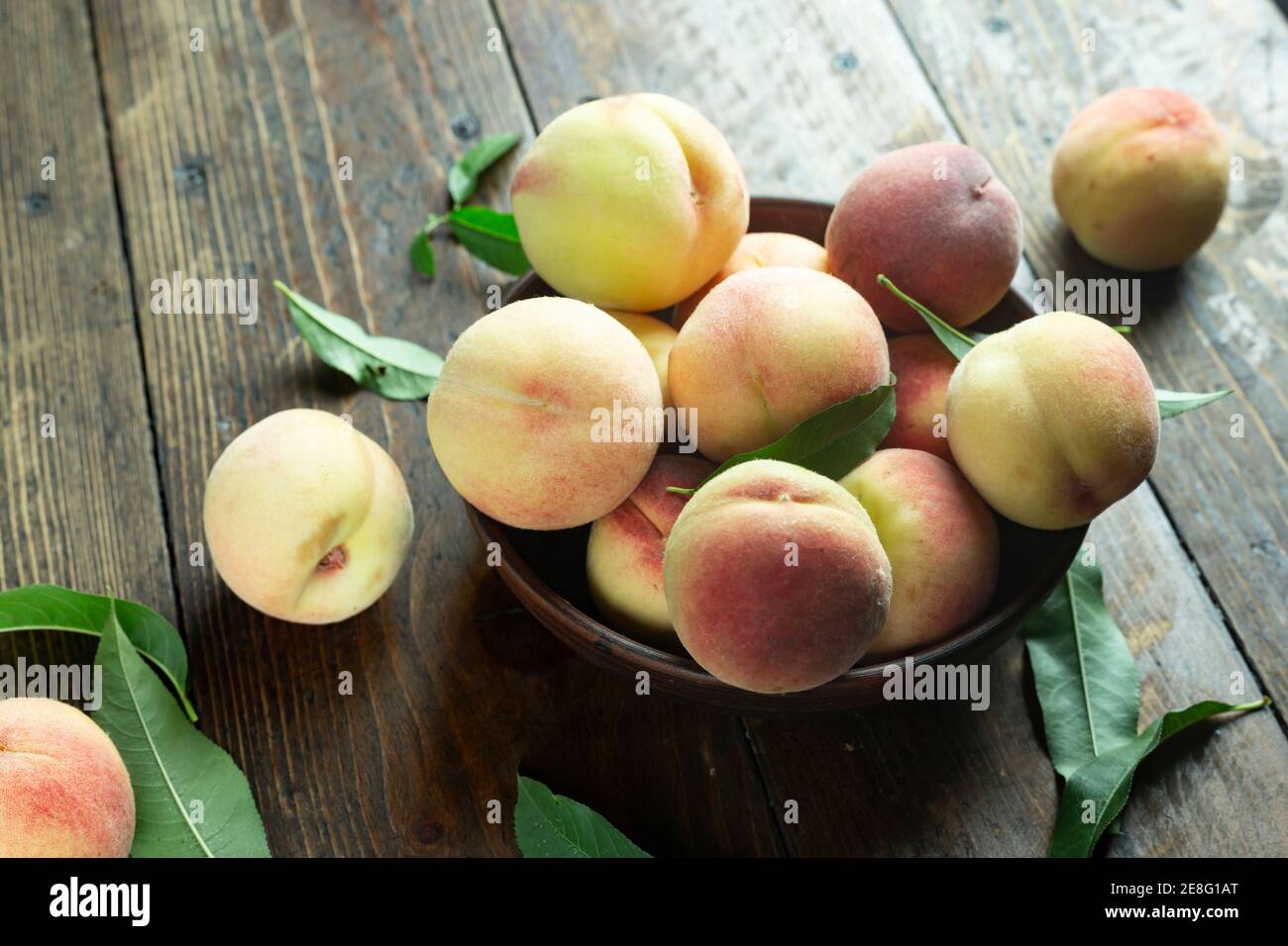 Fresh harvest of peaches in a clay bowl on a wooden rustic table. Peach ...
