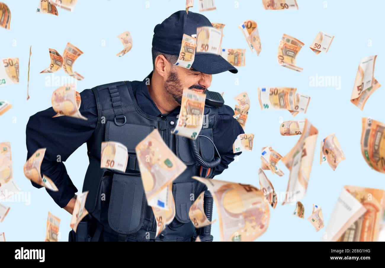 Young hispanic man wearing police uniform suffering of backache ...