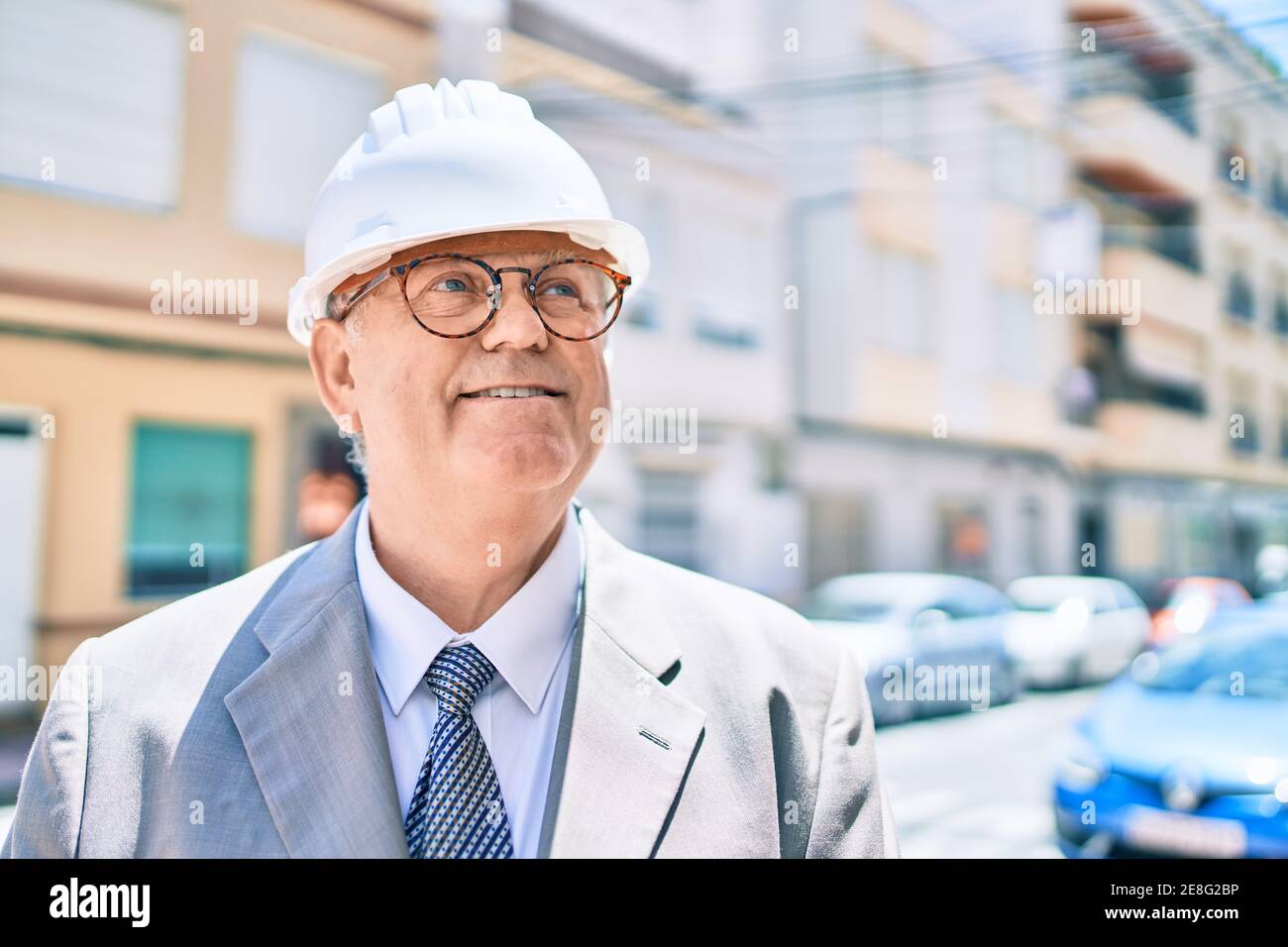 Senior grey-haired architect man smiling happy walking at street of ...