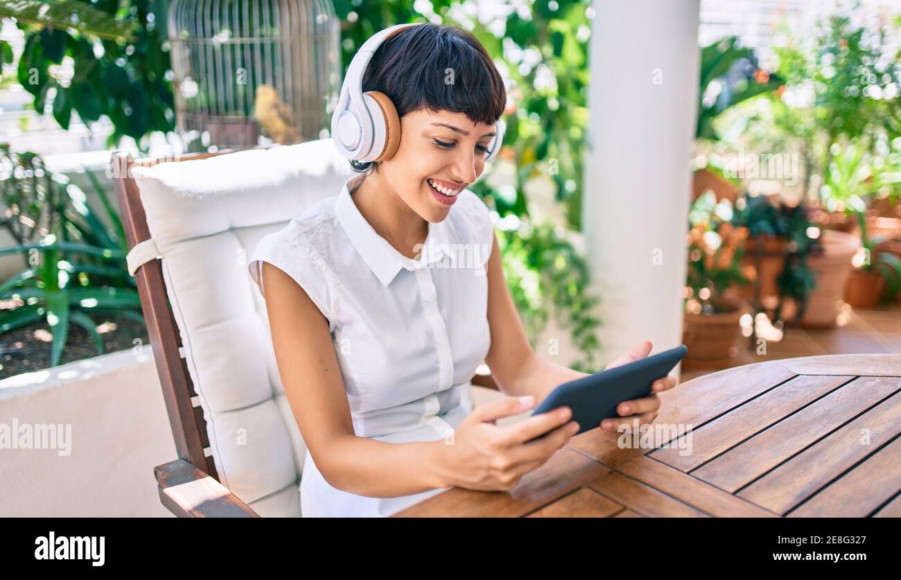 Beautiful woman with short hair sitting at the terrace on a sunny day ...