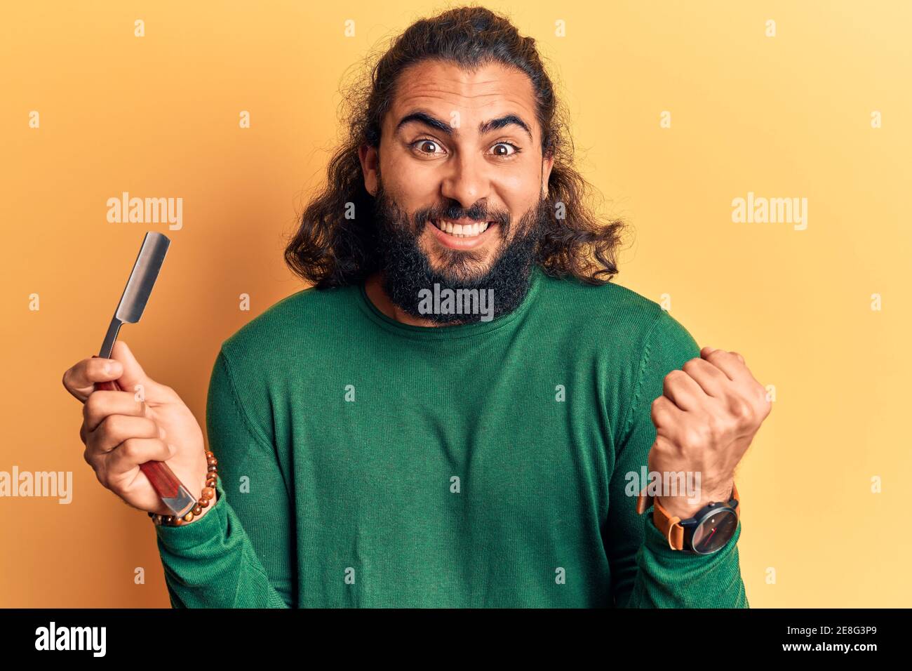 Young arab man holding barber razor screaming proud, celebrating ...