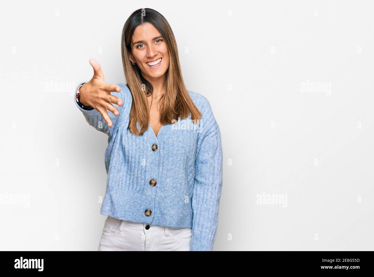 Young woman wearing casual clothes smiling friendly offering handshake ...