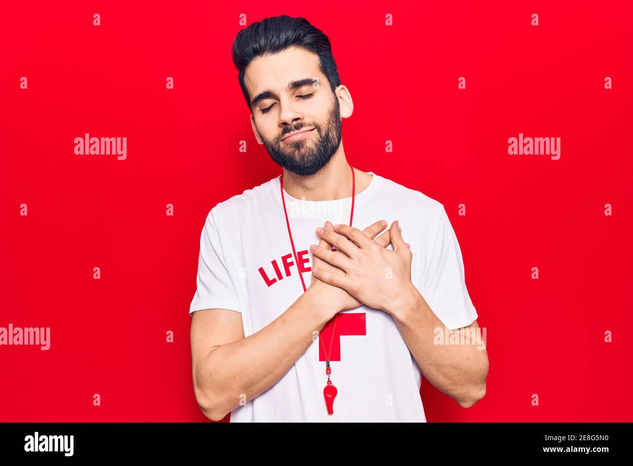 Young handsome man with beard wearing lifeguard t-shirt and whistle ...