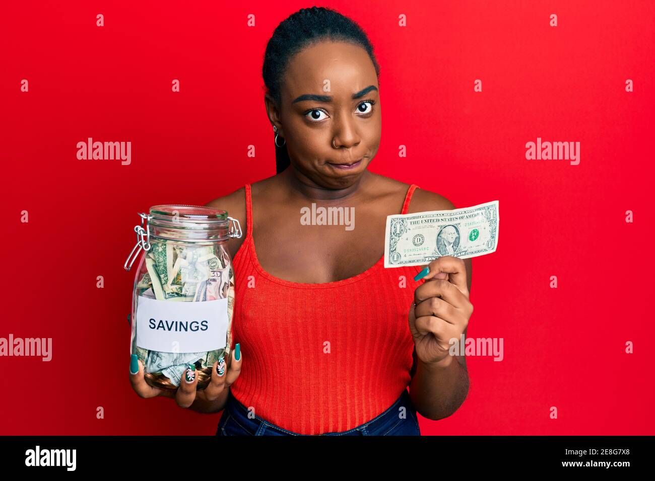 Young african american woman holding jar with savings and 1 dollar ...