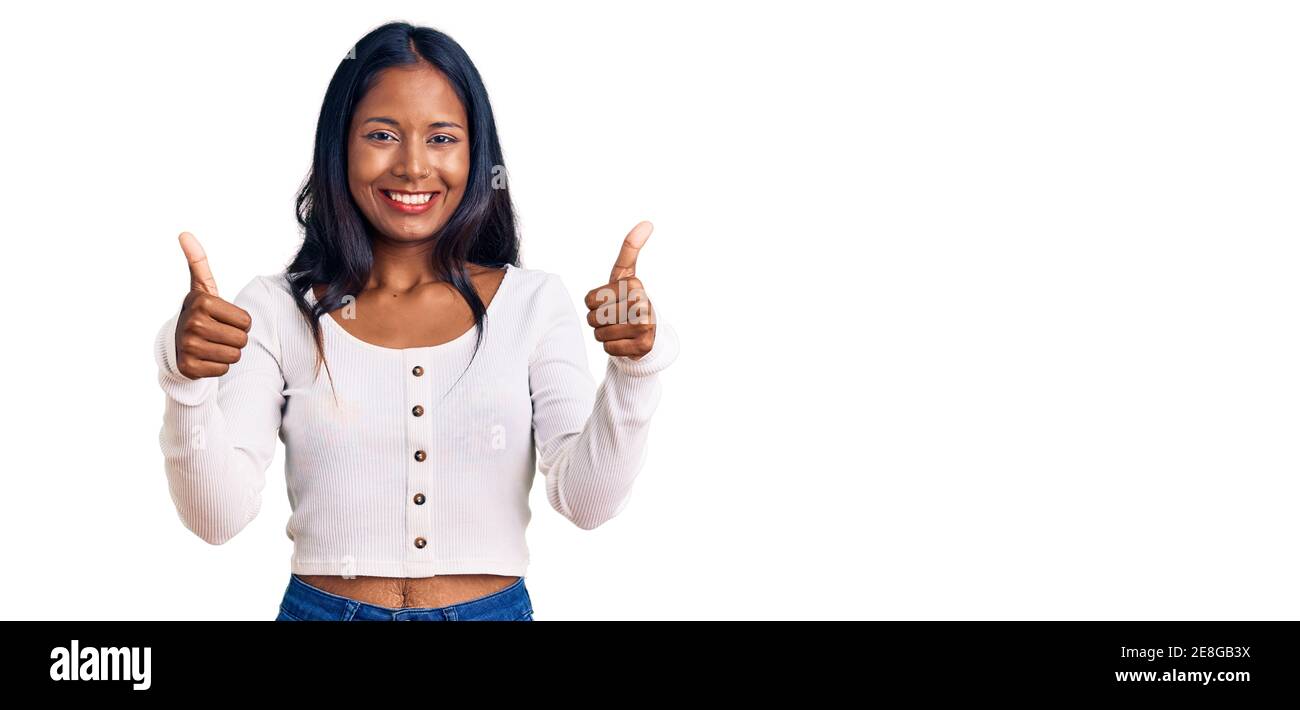 Young indian girl wearing casual clothes success sign doing positive ...