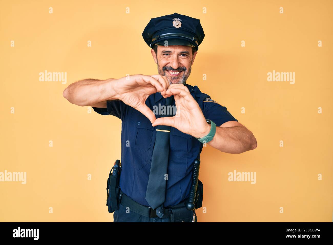 Middle age hispanic man wearing police uniform smiling in love doing ...