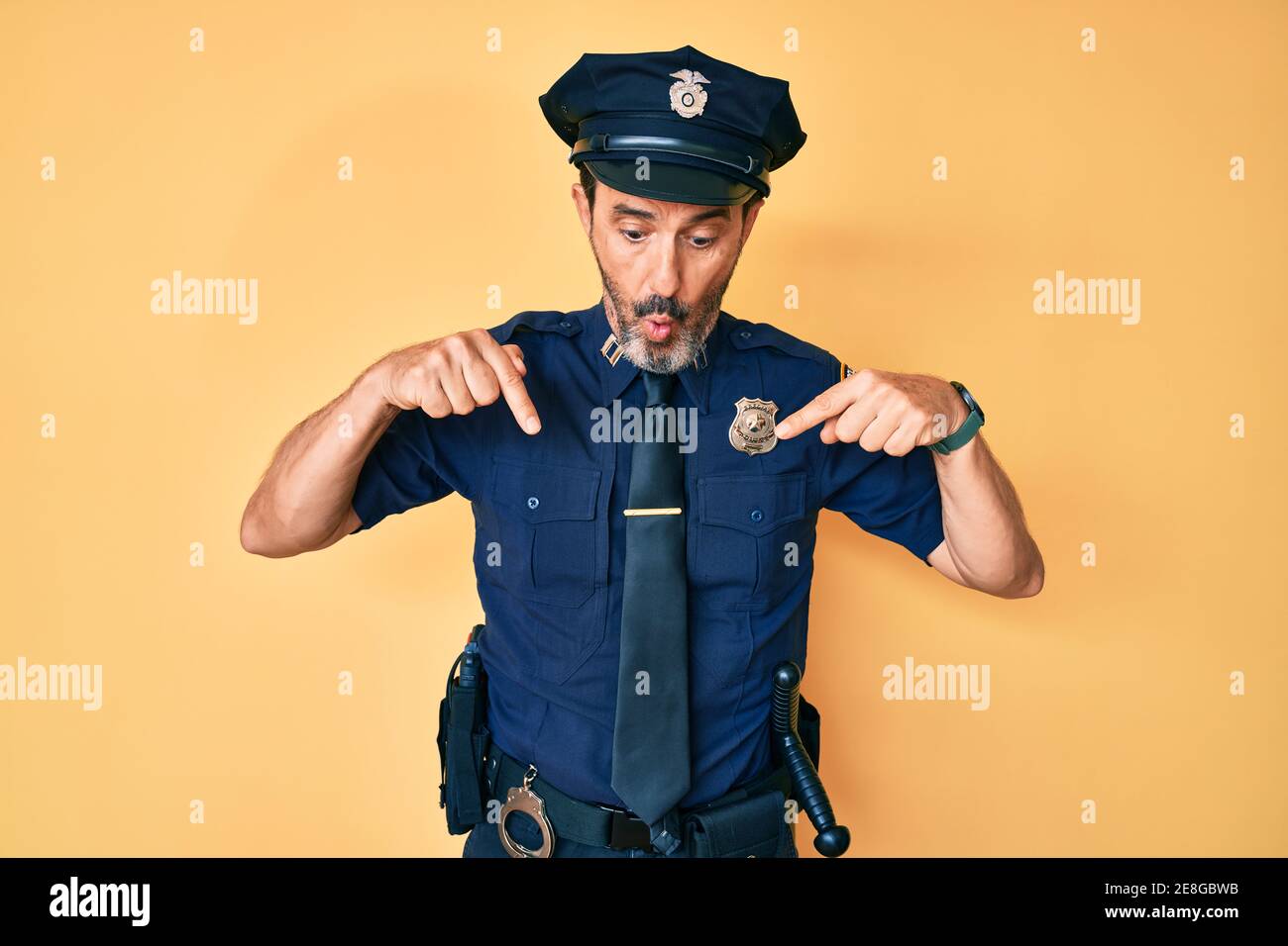 Middle age hispanic man wearing police uniform pointing down with ...