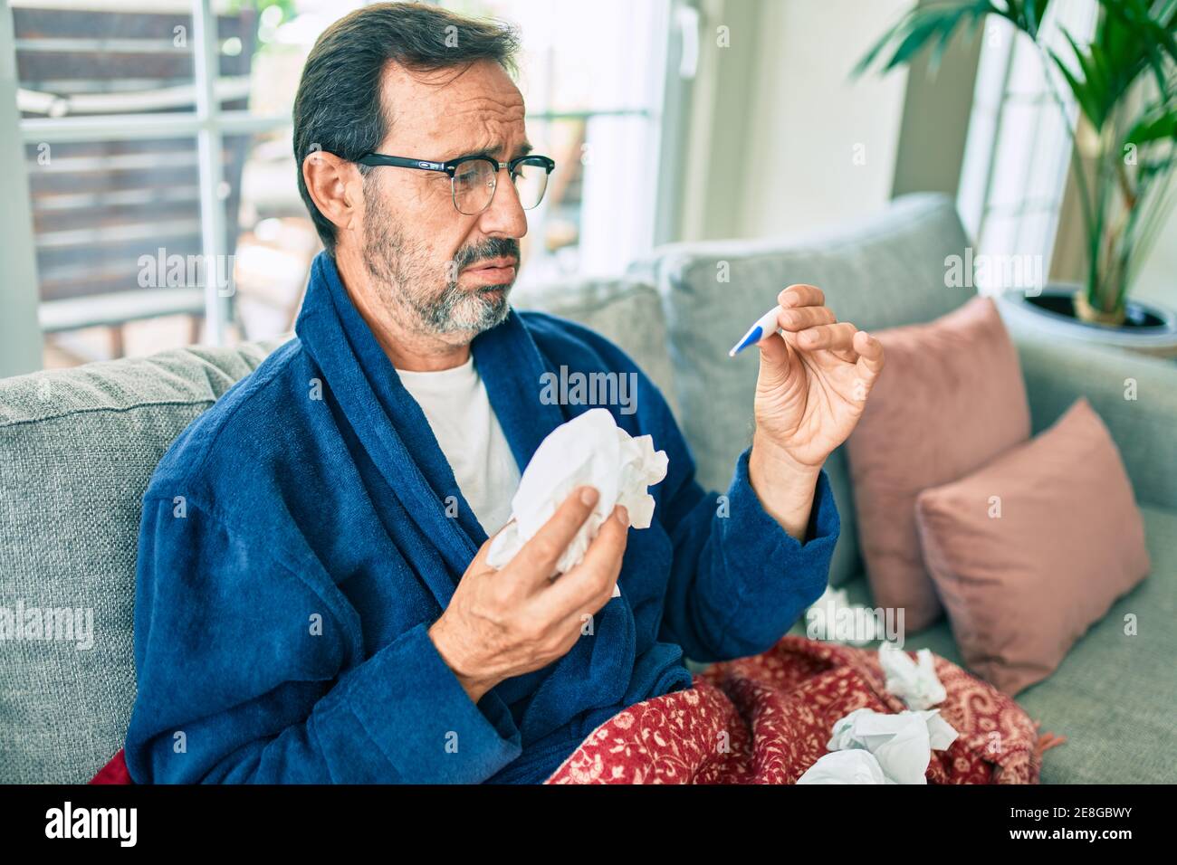 Middle age man feeling sick with cold and fever at home, ill with flu ...