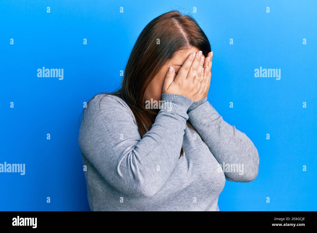 Beautiful brunette plus size woman wearing casual clothes with sad ...