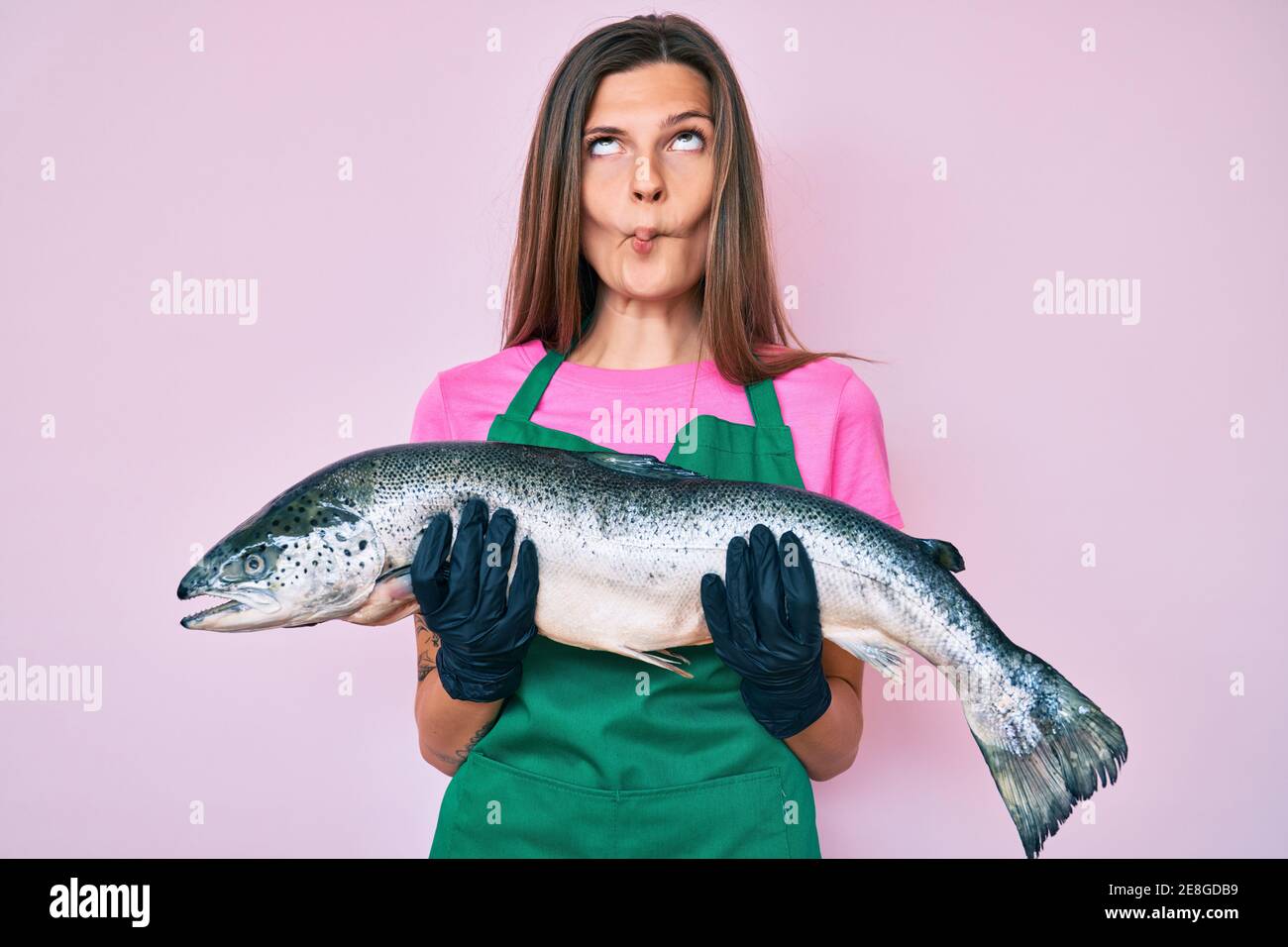 Beautiful caucasian woman fishmonger selling fresh raw salmon making ...