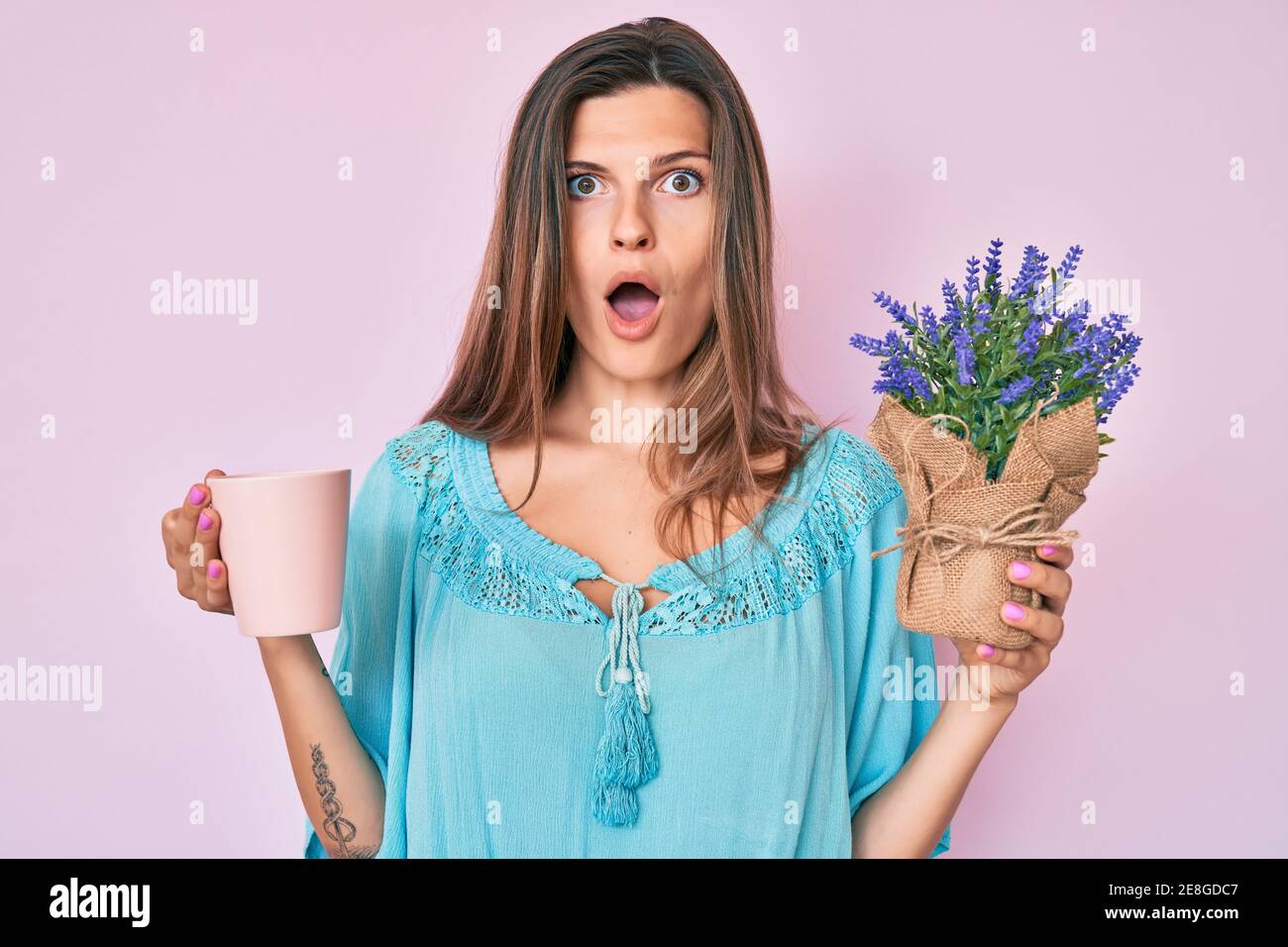 Beautiful caucasian woman drinking a cup of infused lavender afraid and ...