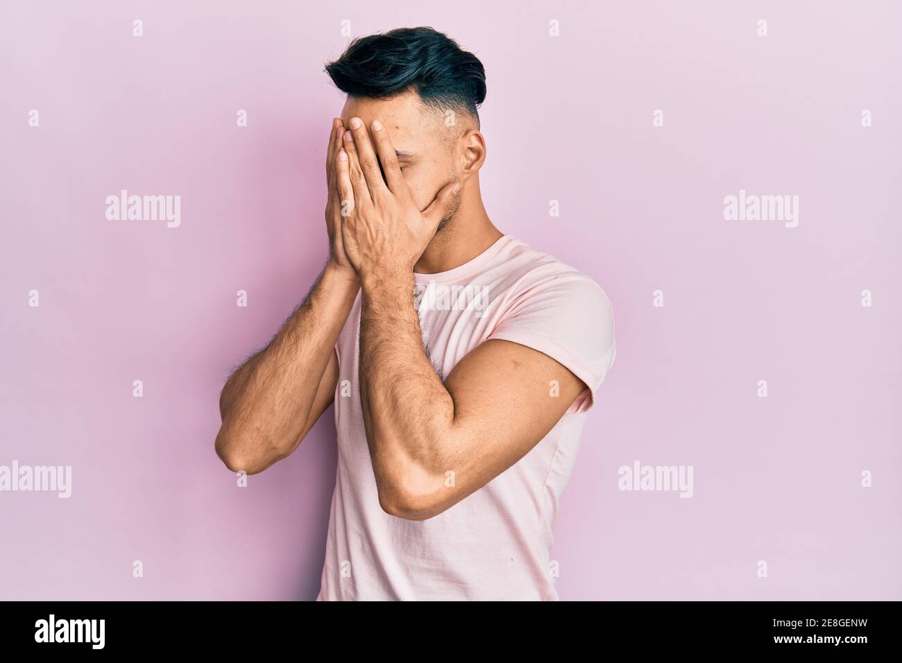 Young arab man wearing casual clothes with sad expression covering face ...