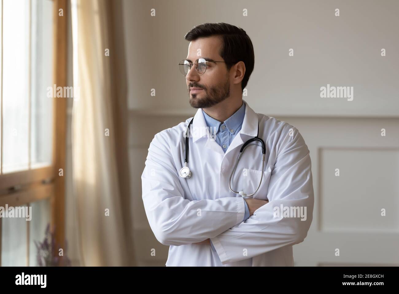 Pensive male doctor look in distance thinking Stock Photo - Alamy