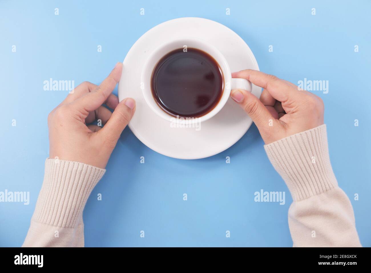 hand holding tea cup on light blue background Stock Photo - Alamy