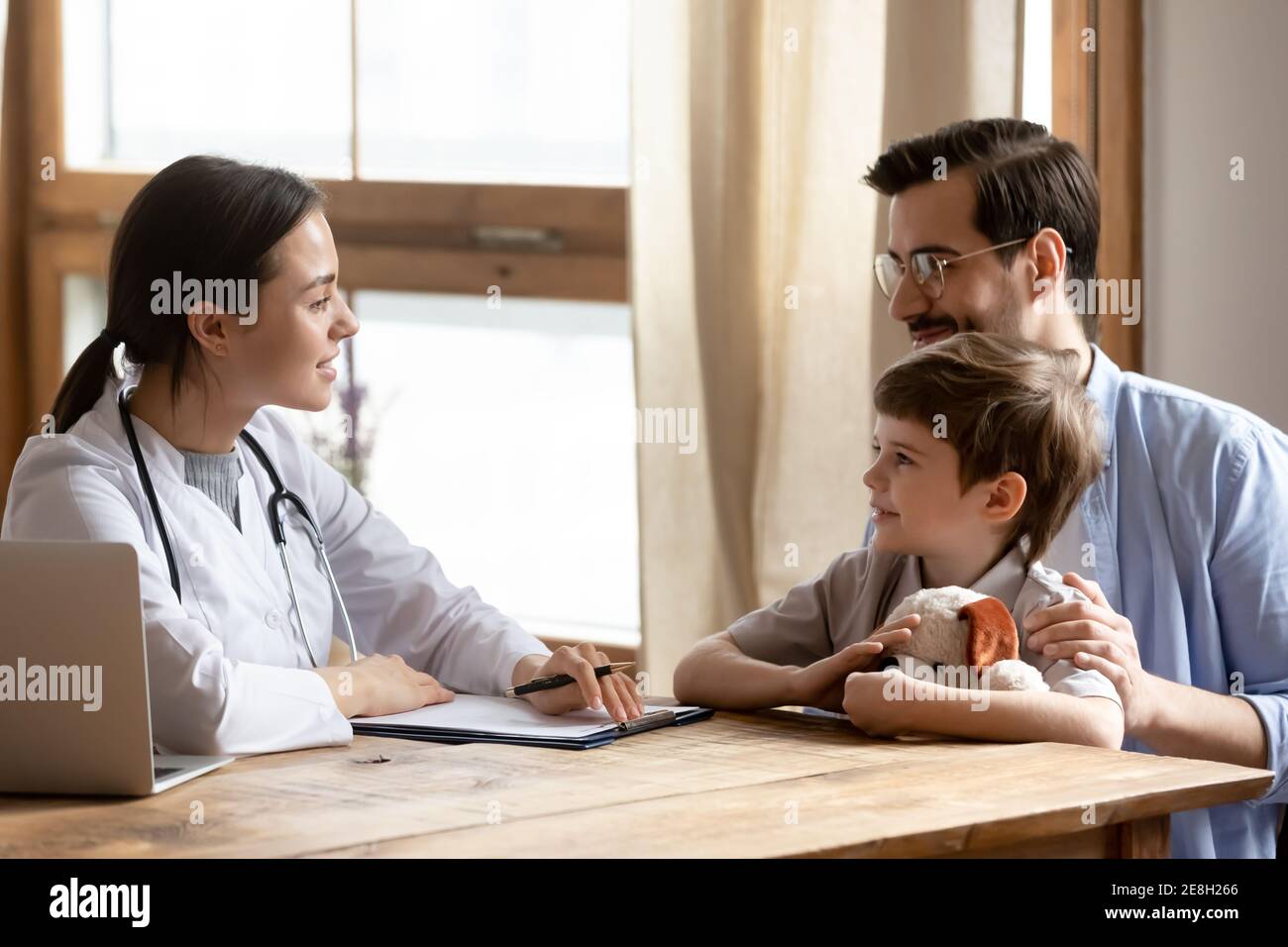Female doctor consult small child visiting with dad Stock Photo - Alamy