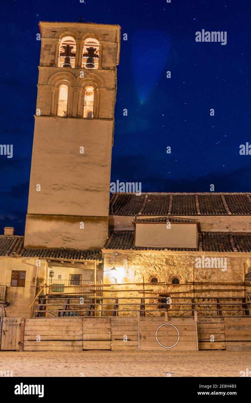 Old bullring in the main square of a town at night next to the church ...