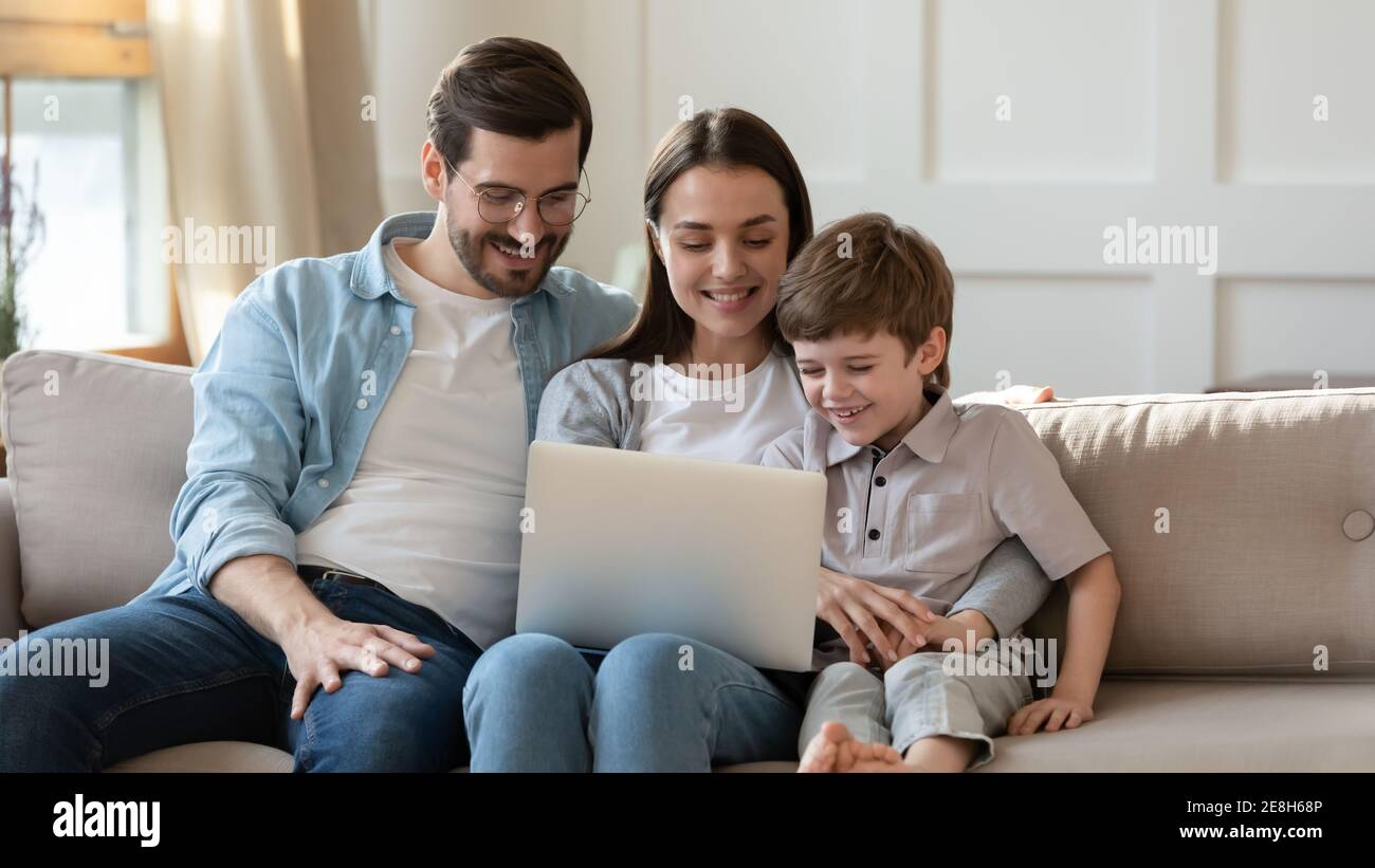 Happy family with small kid watch video on computer Stock Photo - Alamy