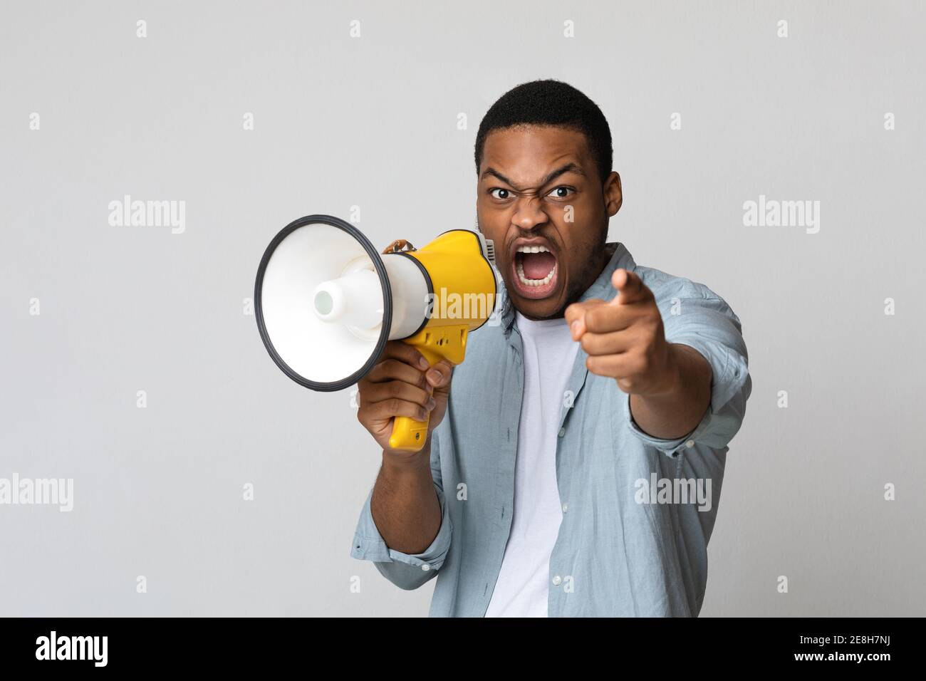 Young black man shouting in megaphone over grey background Stock Photo ...