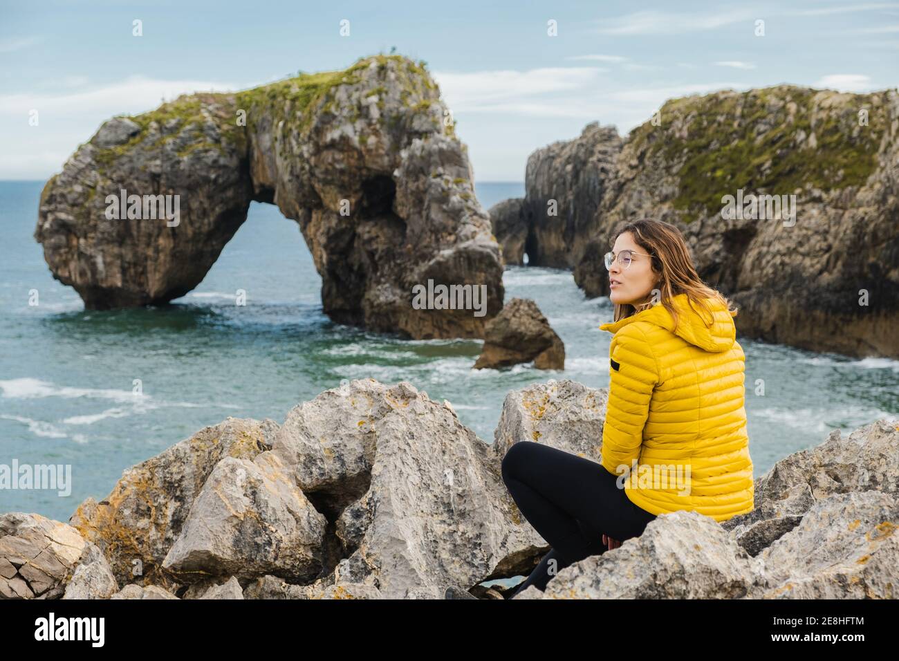 Side view of unrecognizable barefooted female in activewear doing Kneeling yoga pose on mat near ...