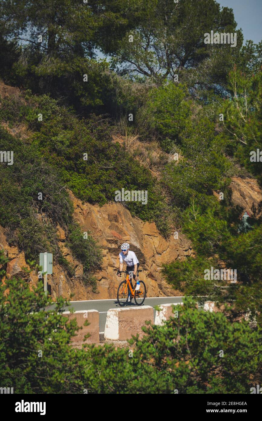 Full body of young sportsman in activewear and helmet riding bicycle on ...