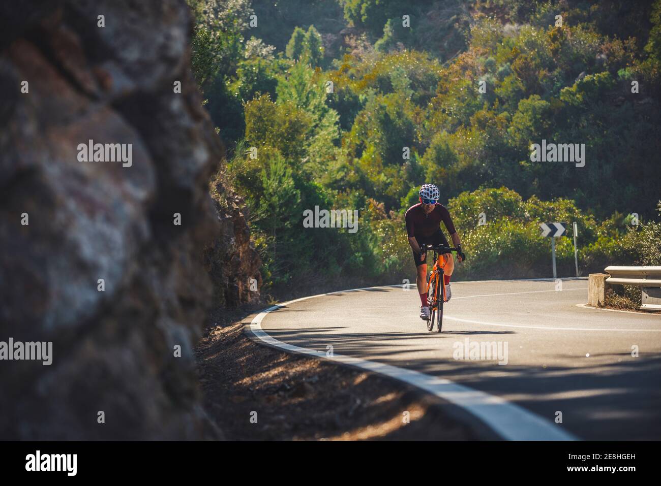 Full body of young sportsman in activewear and helmet riding bicycle on ...
