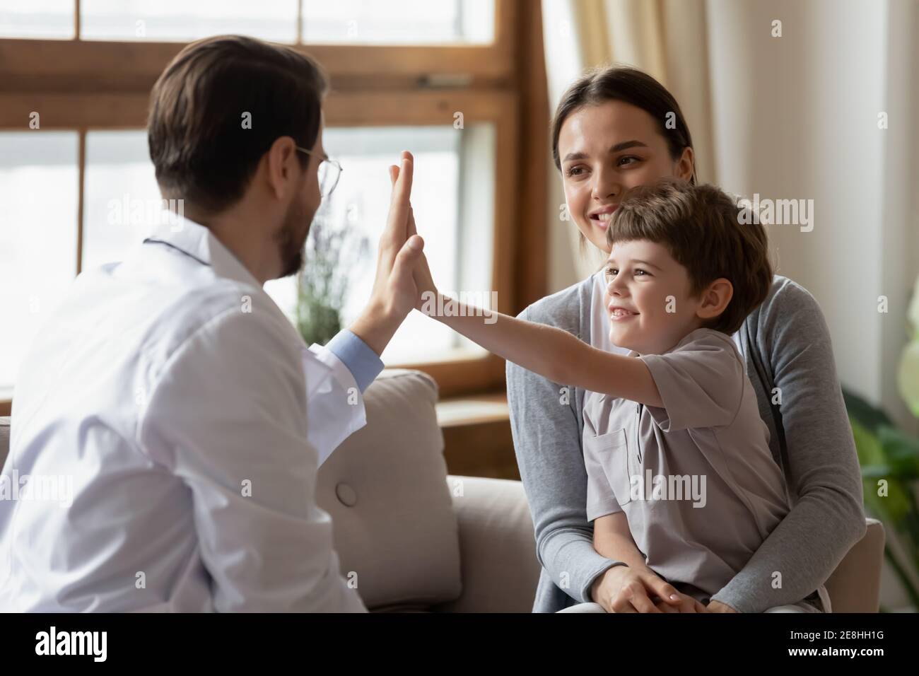 Happy boy patient give high five to caring doctor Stock Photo - Alamy
