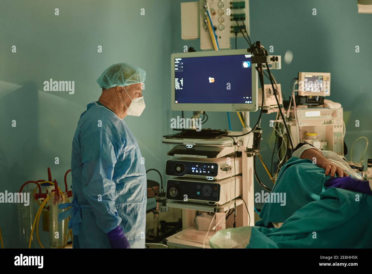Side view of unrecognizable elderly male doctor in surgical gown and ...