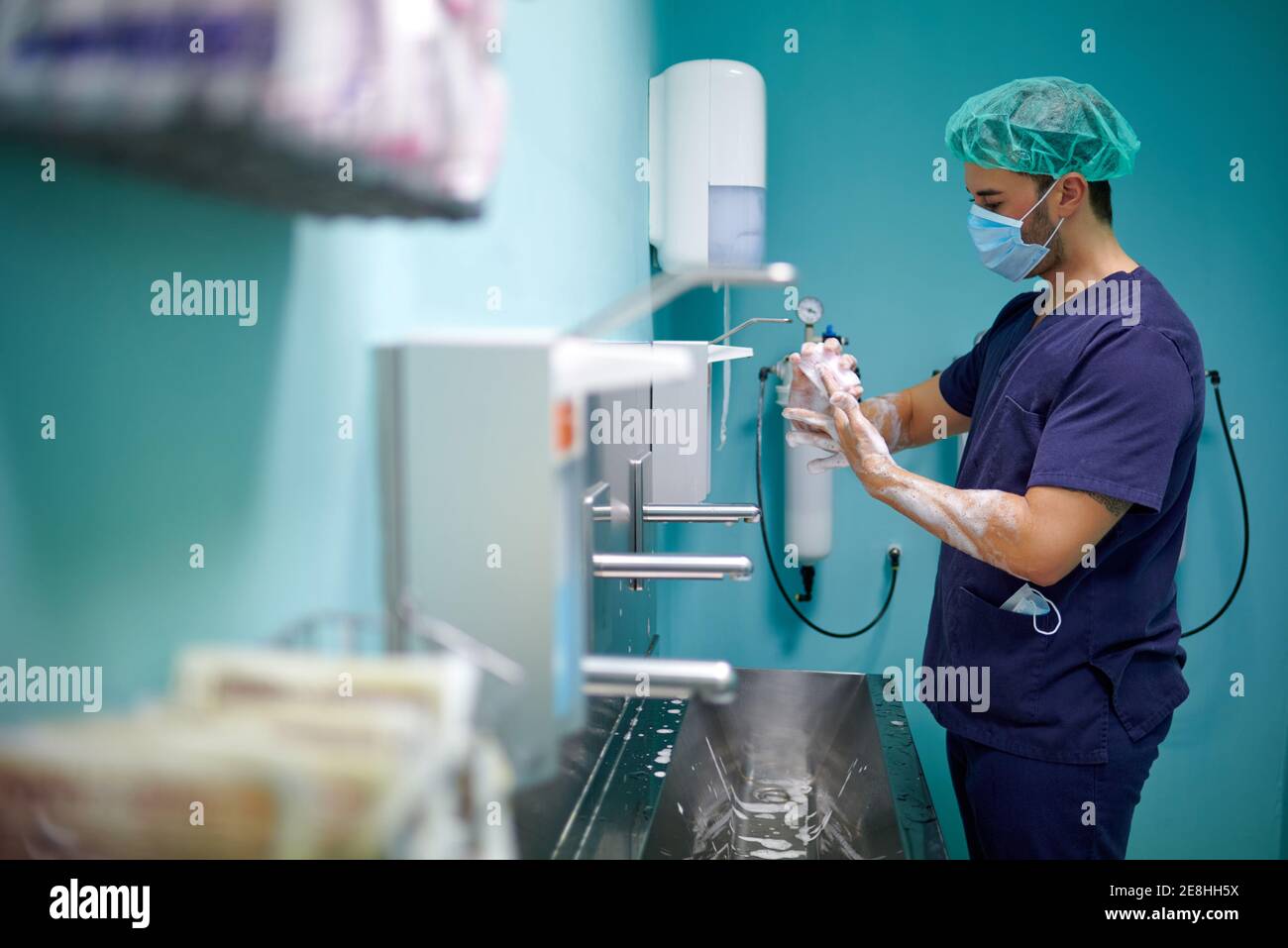 Side view of anonymous young male doctor in medical uniform and mask ...