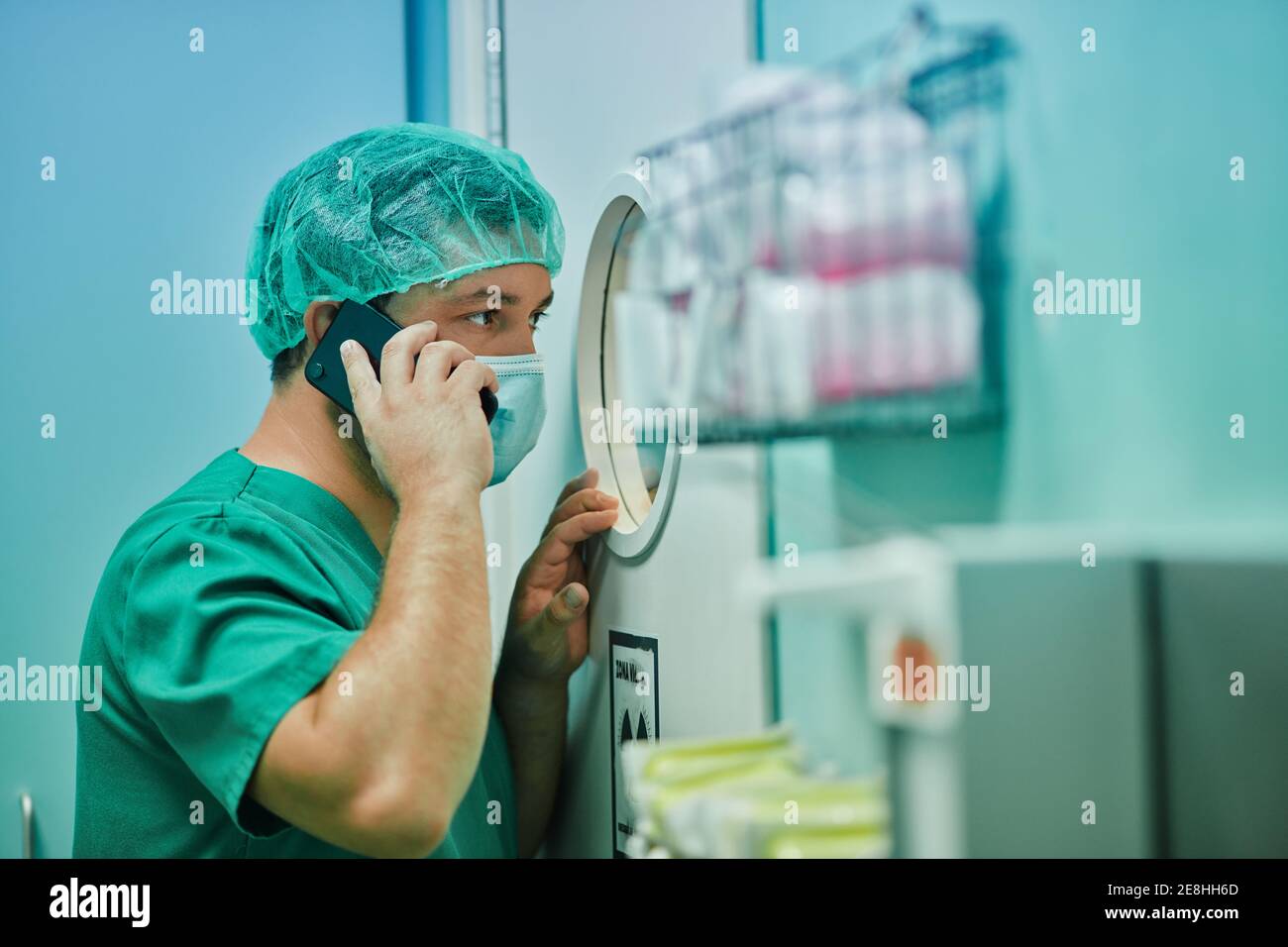 Side view of concentrated young male doctor in uniform and mask having ...