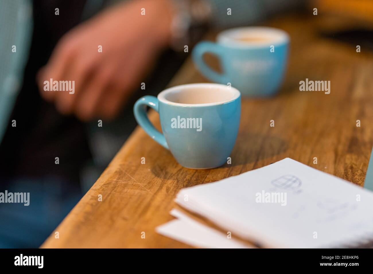 Small cups for espresso placed on wooden counter with notebook on ...