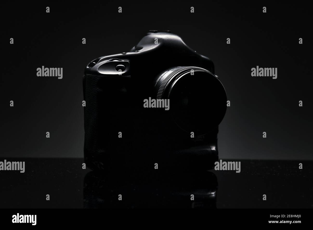 The silhouette of a professional SLR camera on a black background ...